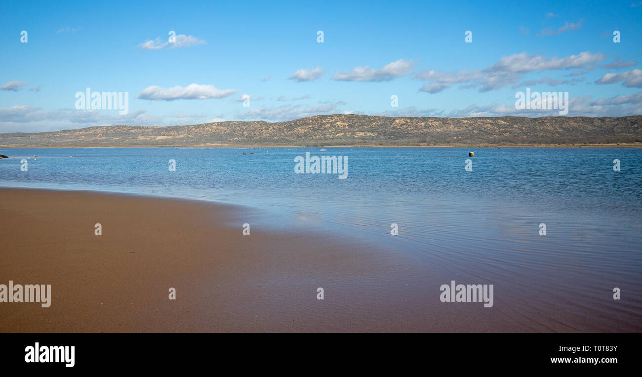 Clouds reflecting in the water on isthmus of sand between Pacific ocean ...