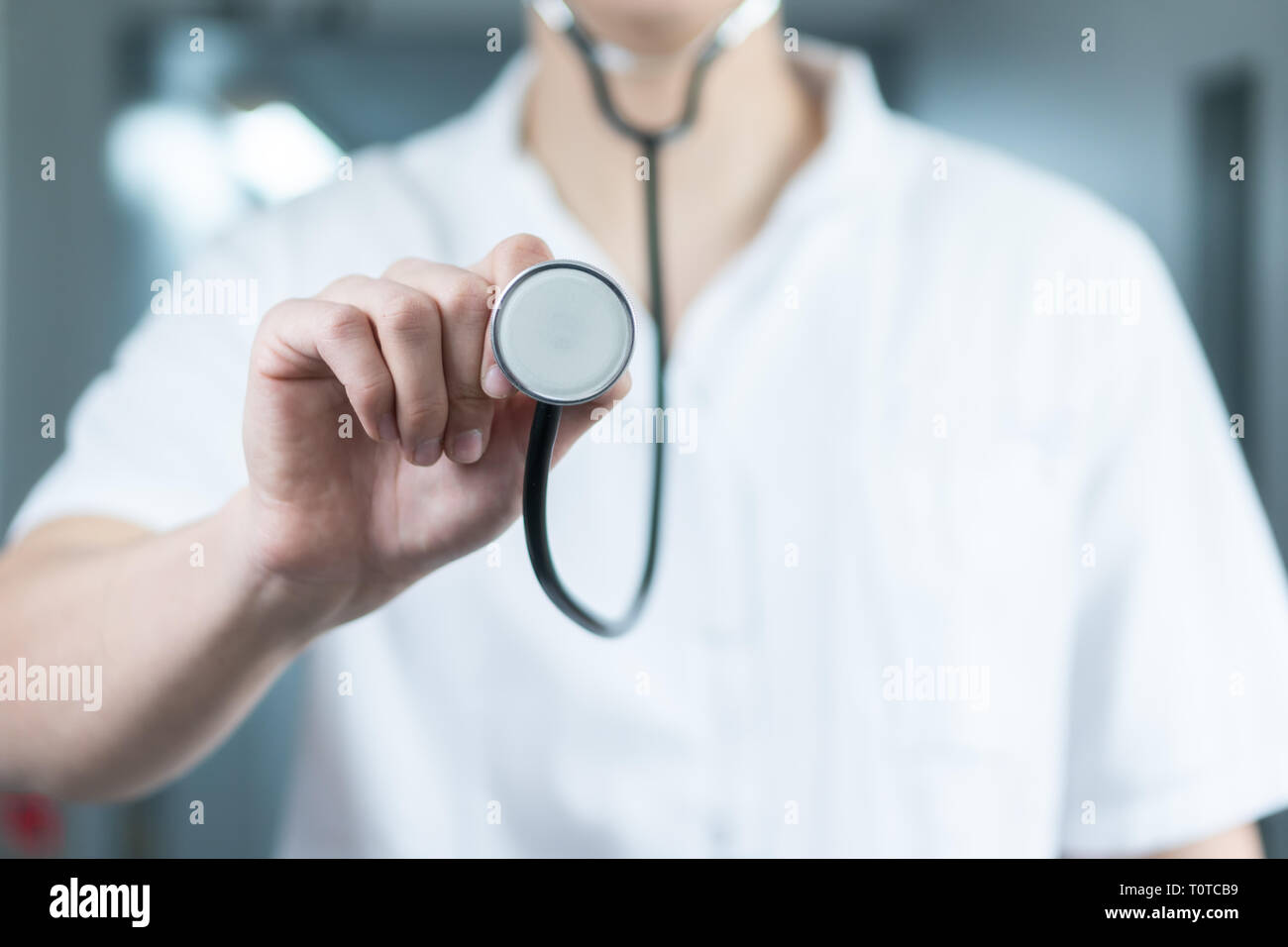 Bright close up of male doctor in uniform with stethoscope. Listening ...