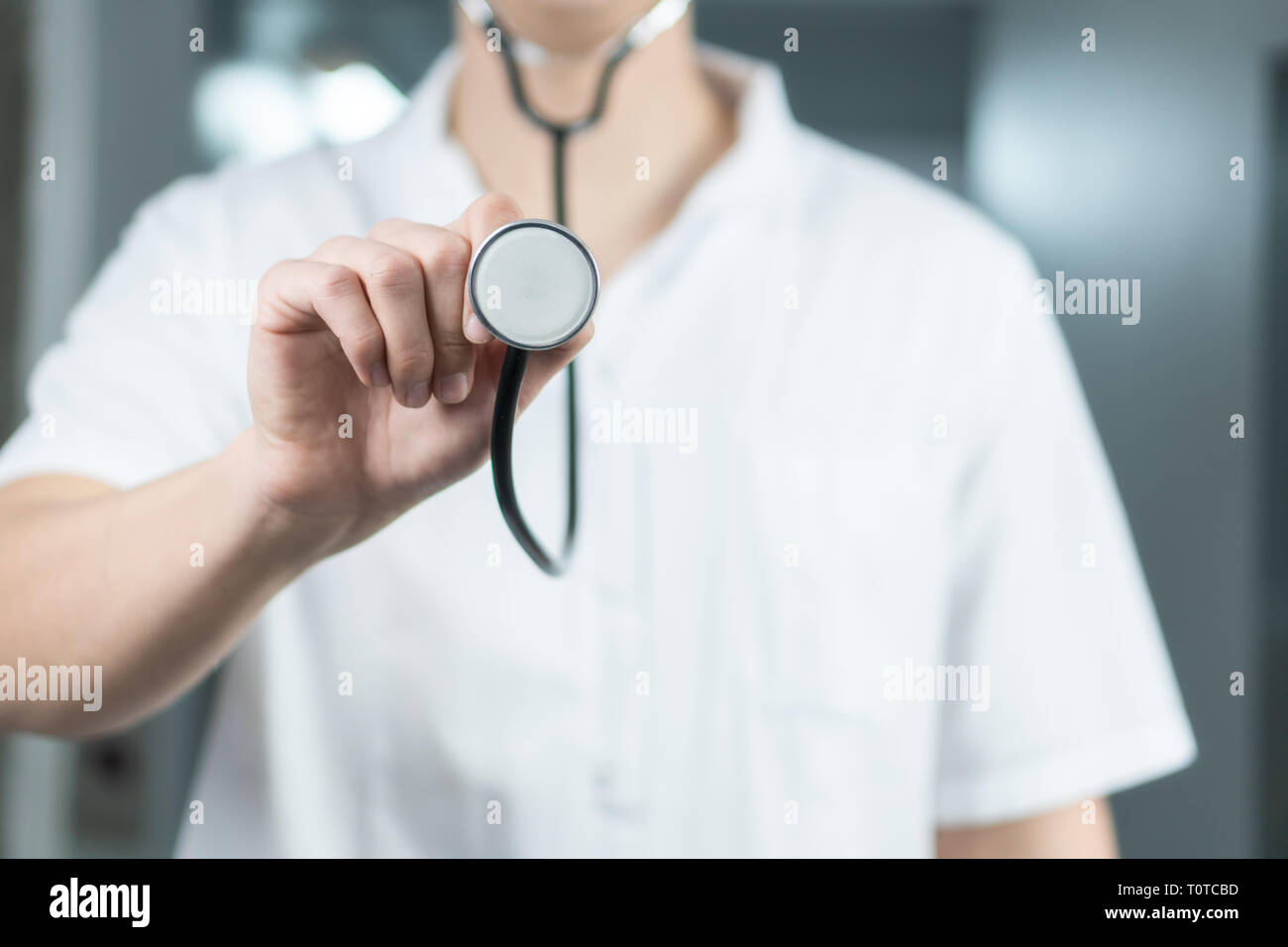 Bright close up of male doctor in uniform with stethoscope. Listening ...