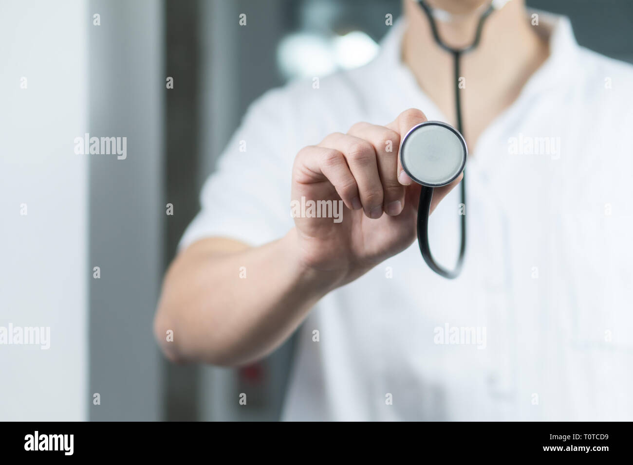 Bright close up of male doctor in uniform with stethoscope. Listening ...