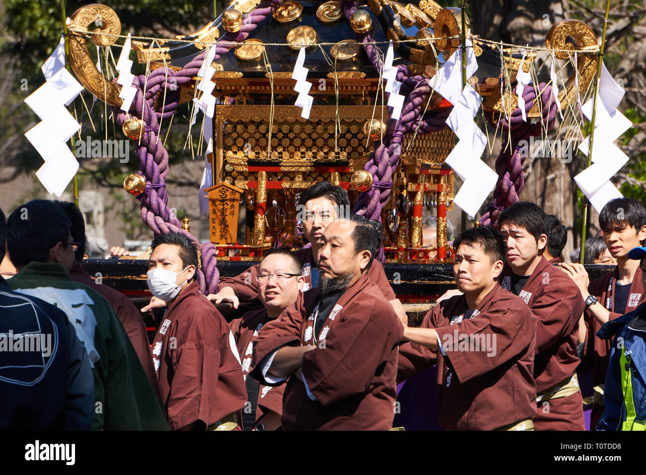 People carry the mikoshi (portable shrine housing the kami or god) at ...