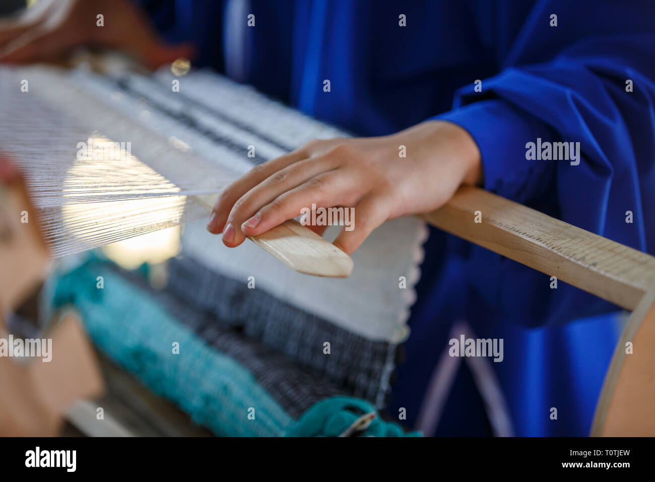Hands of woman weaving fabric on a wooden loom. Traditional Russian ...