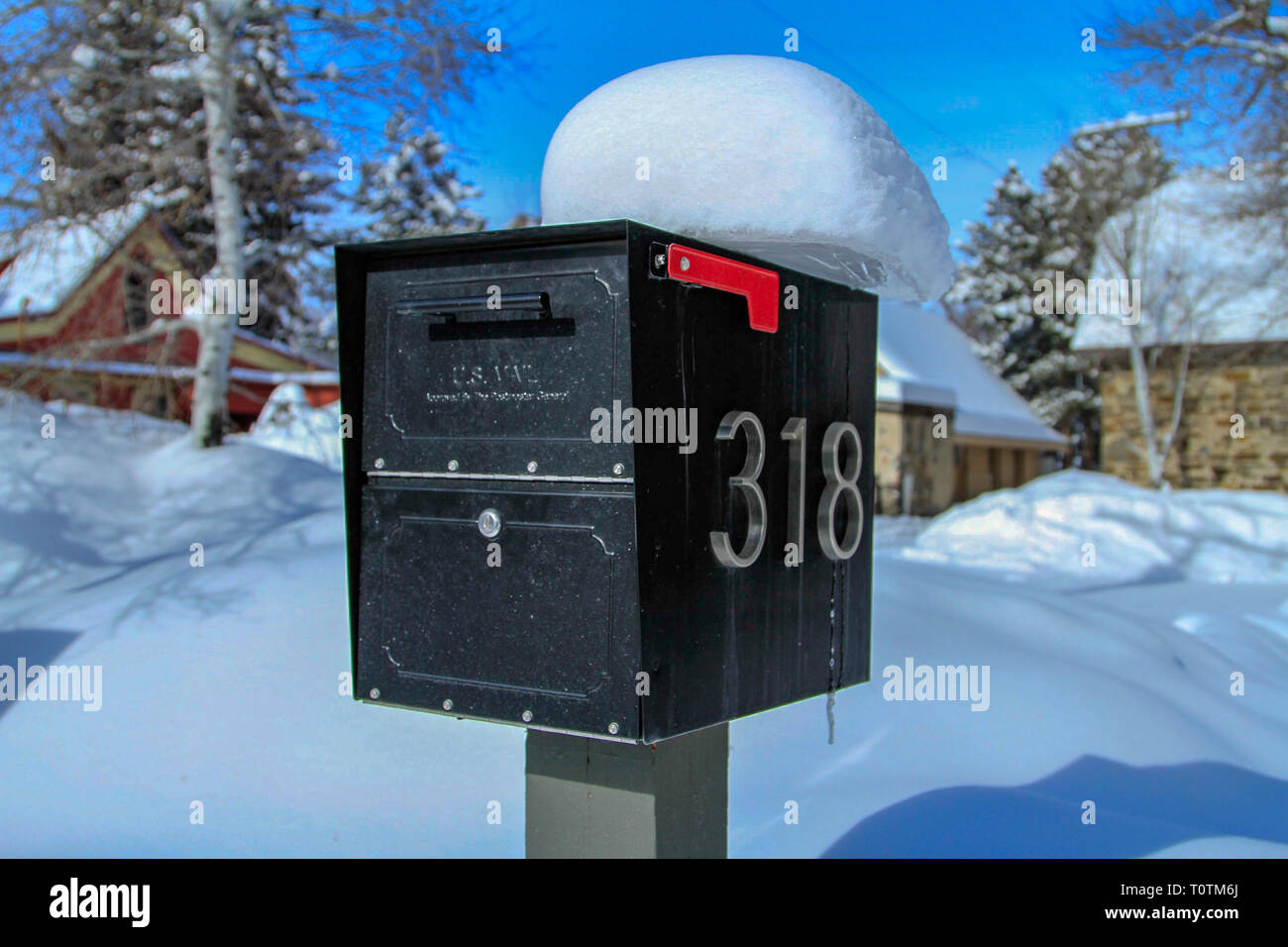 Modern mailbox with snow precariously hanging off the top during the ...