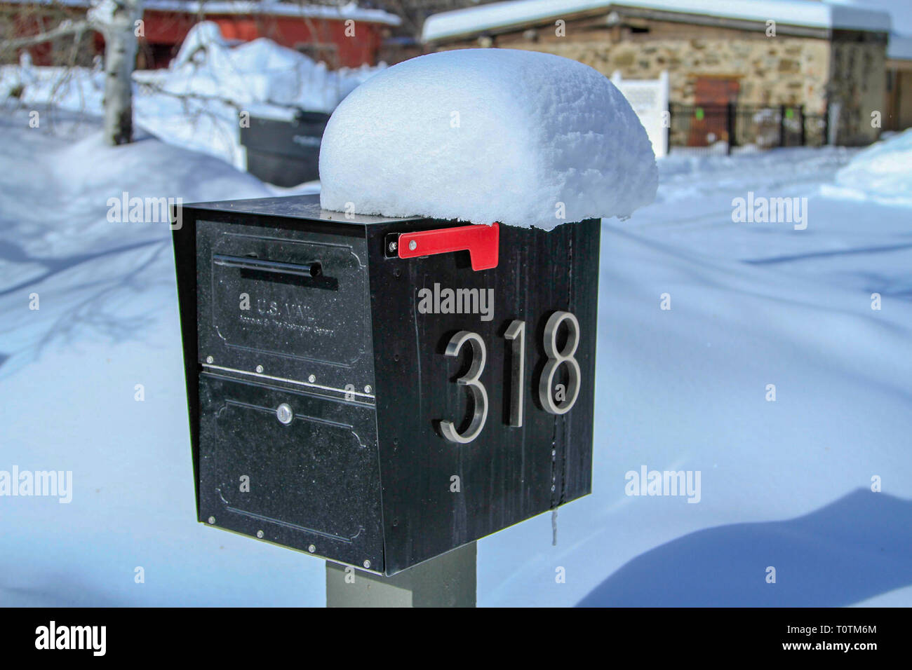 Modern mailbox with snow precariously hanging off the top during the ...