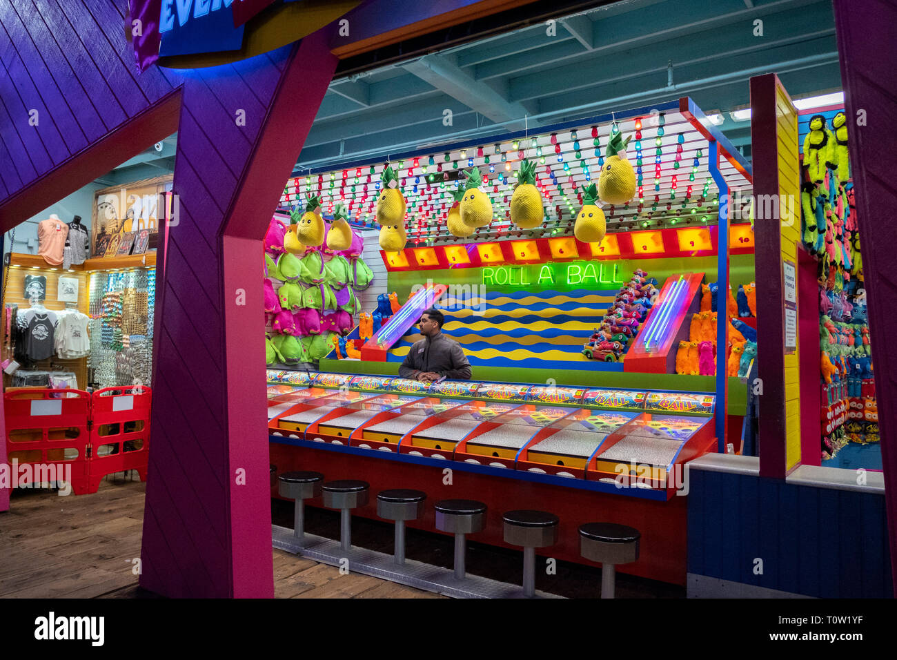 Worker manning a game at Pacific Park amusement park, Santa Monica Pier ...