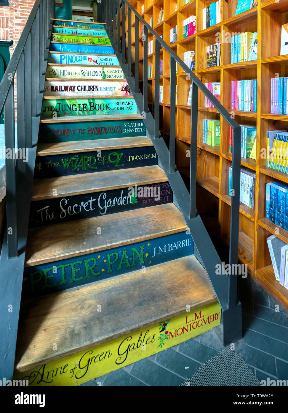 Colorful book shelves packed with books in a library. This is an ...