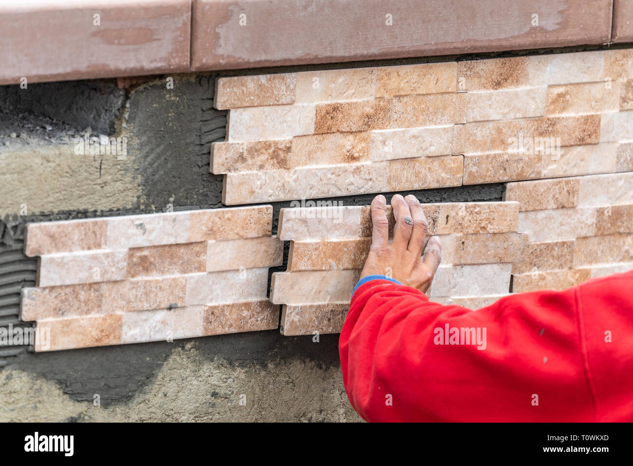Worker Installing Wall Tile at Construction Site Stock Photo - Alamy