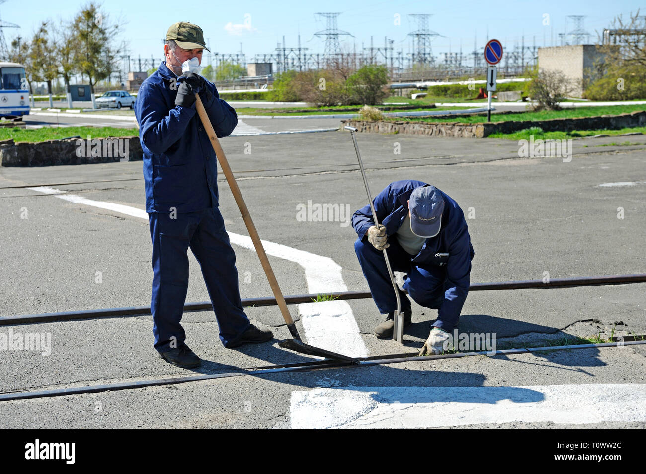 Workers in protective clothes decontaminating square near building of ...