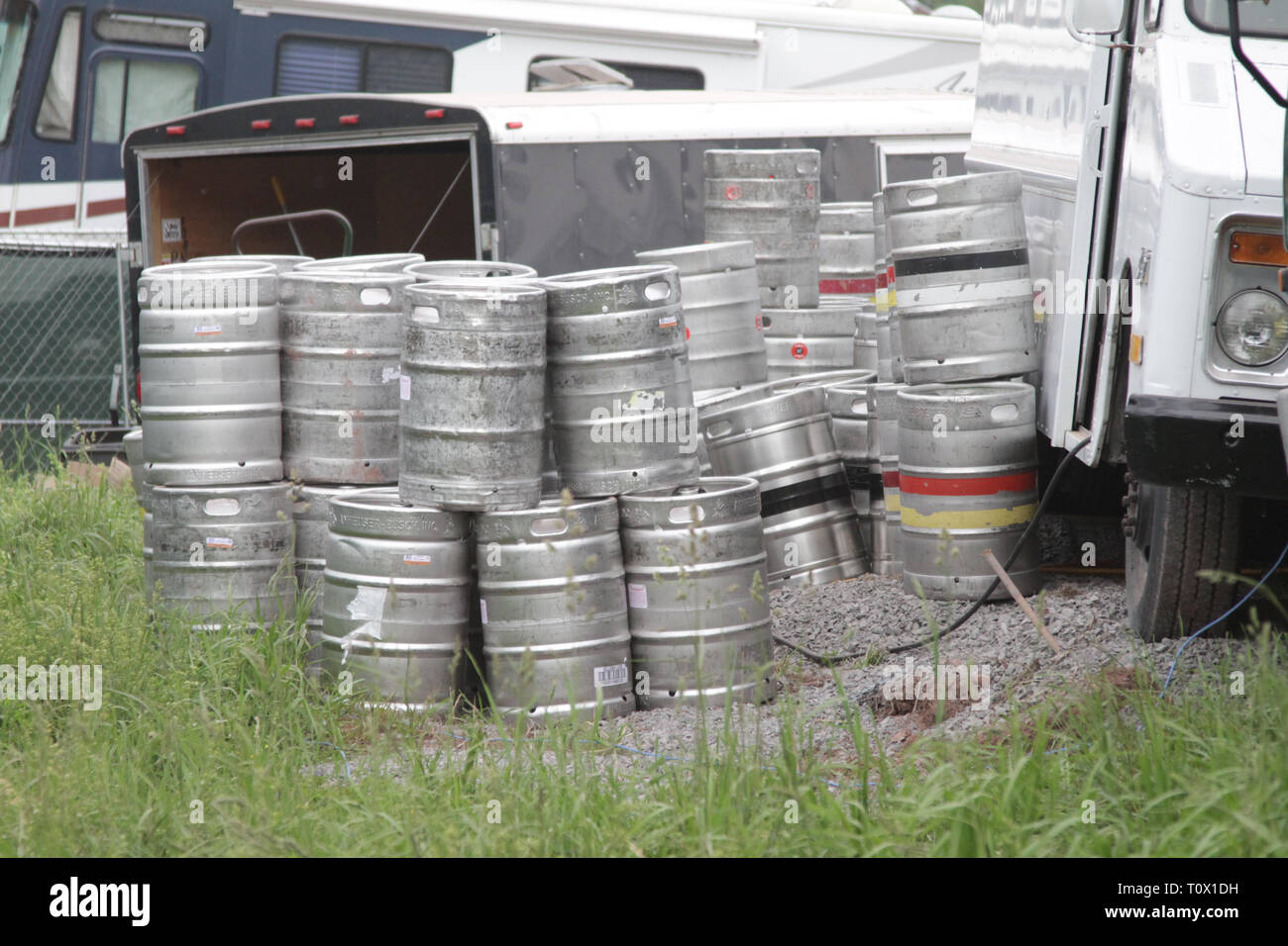 Empty beer kegs are shown stacked in storage at an outdoor concert ...