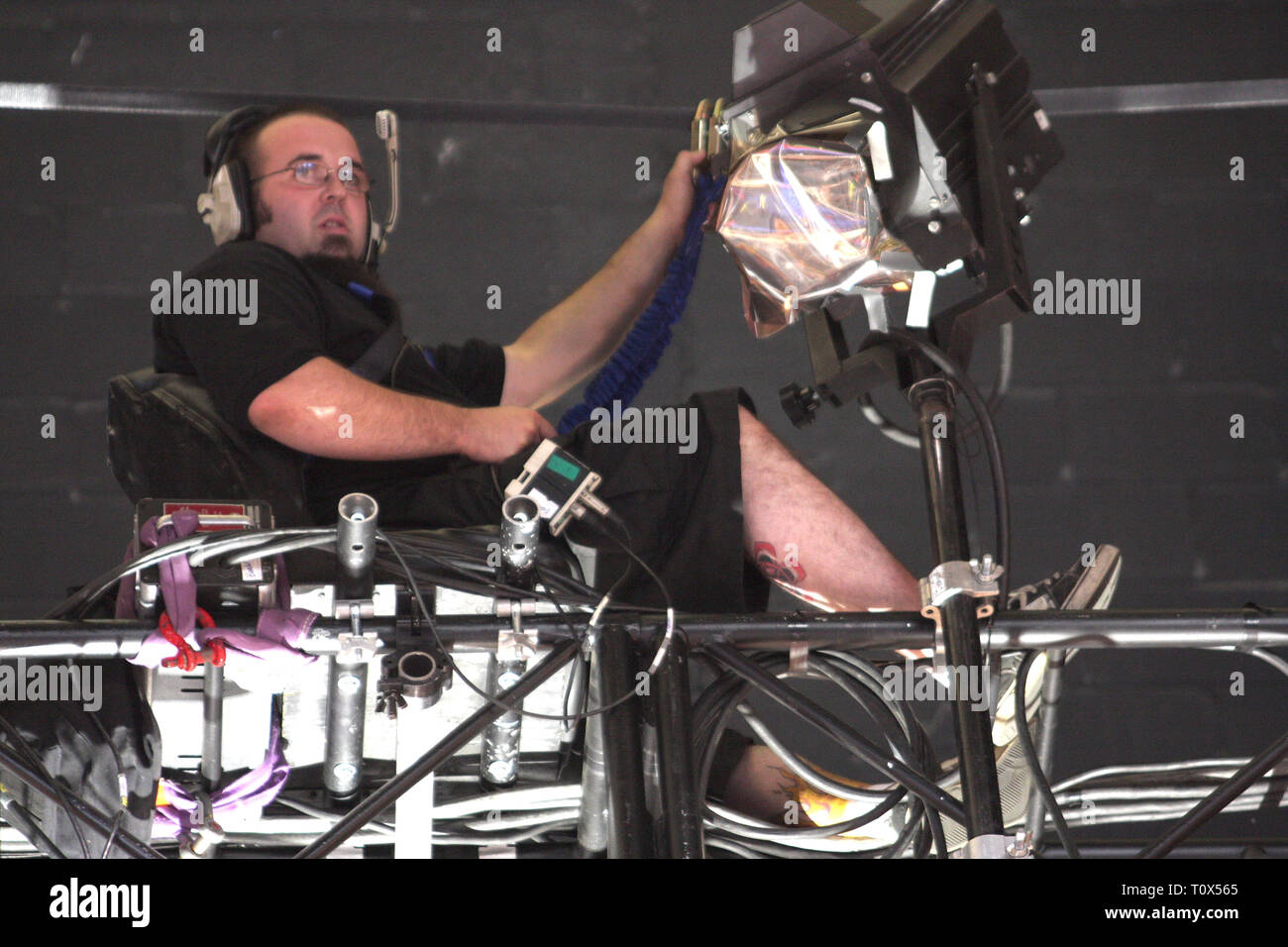 A lighting technician is shown working high above the stage during a ...