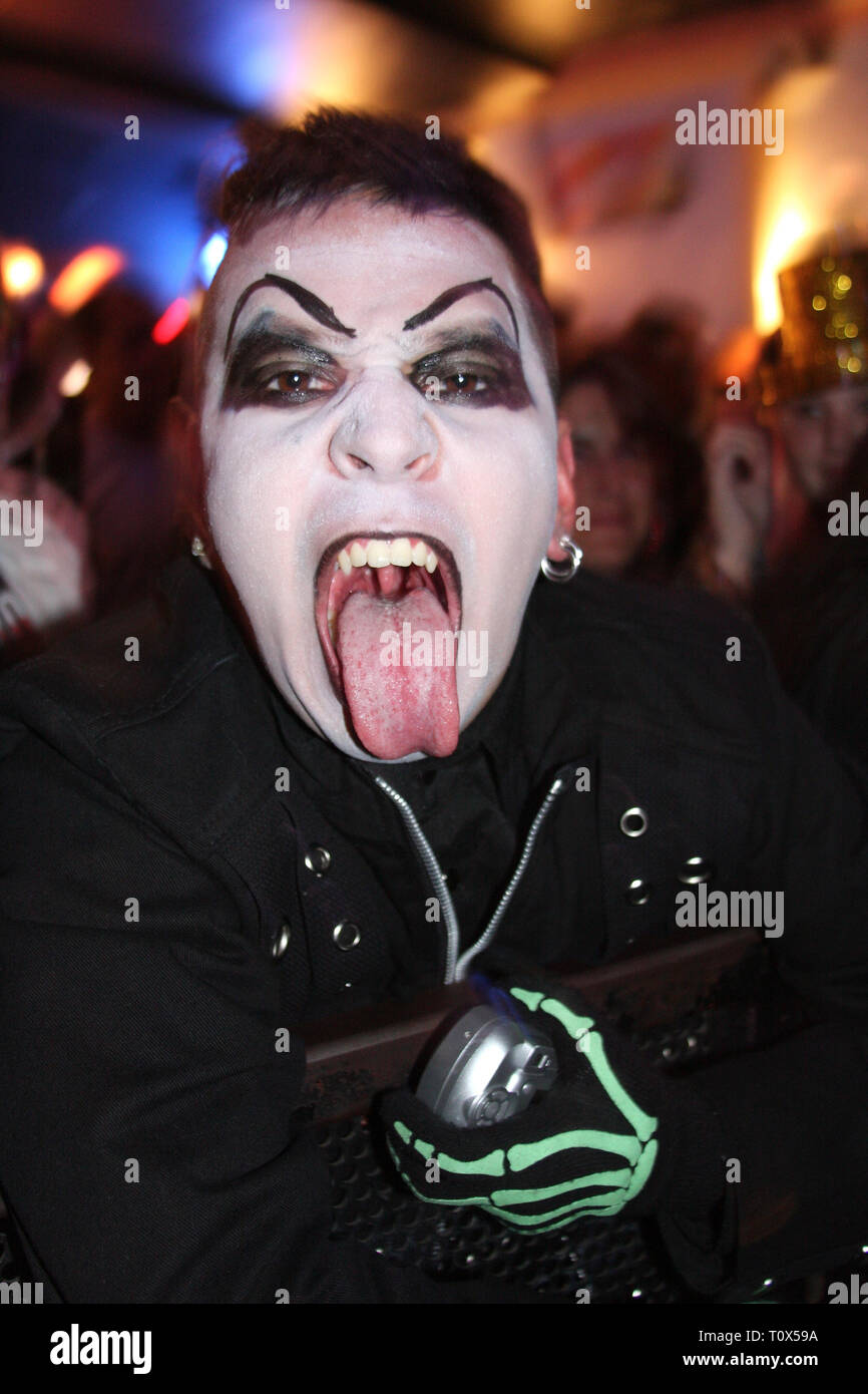 A face painted concert fan is showing posing for the camera at a ...