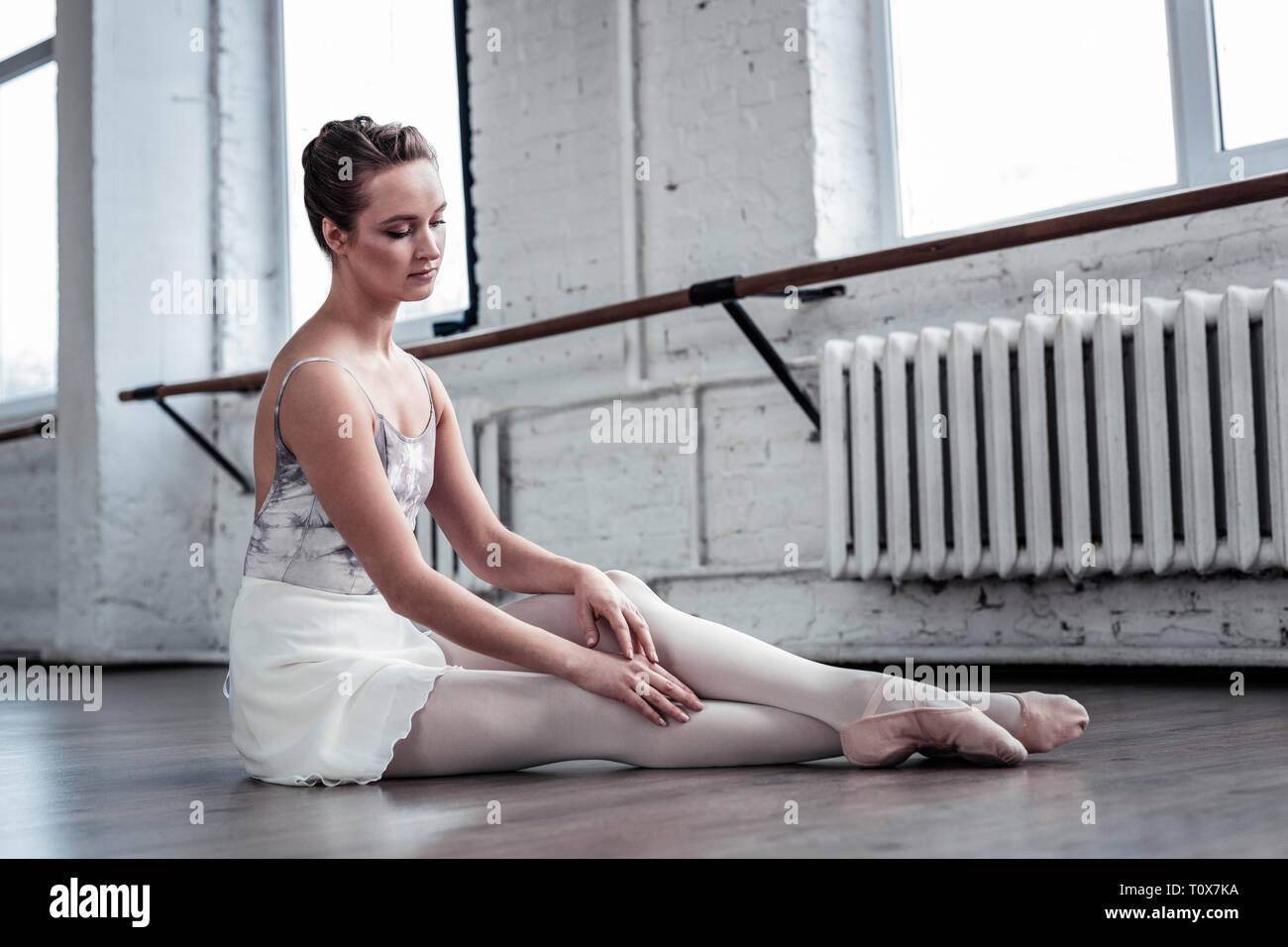 Nice serious young woman looking at her legs Stock Photo - Alamy