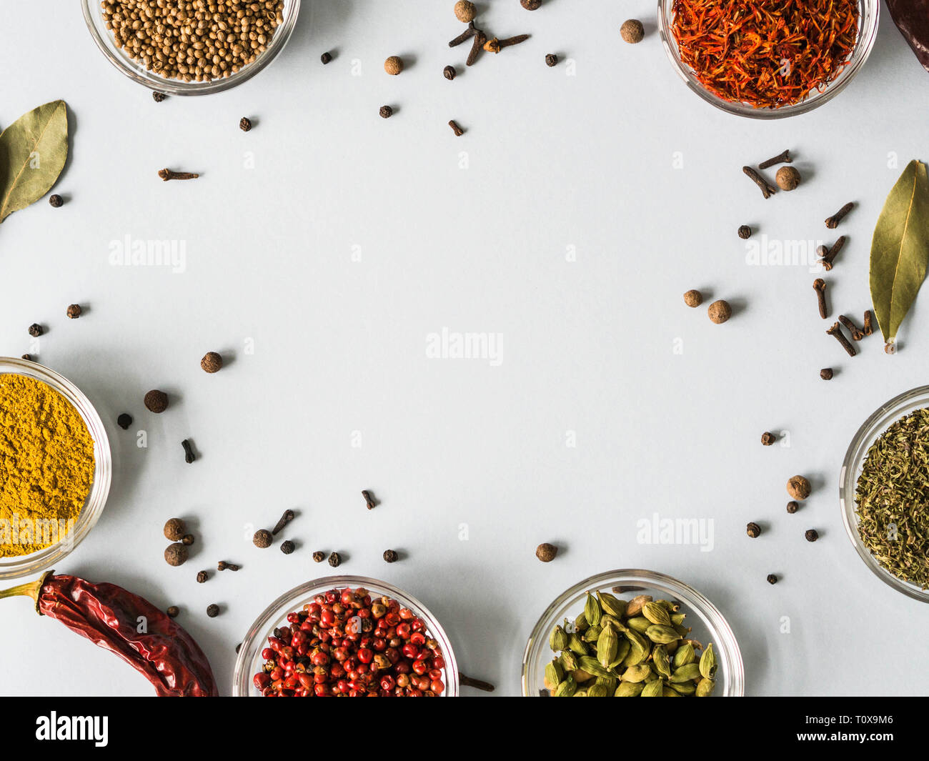 Various spices in glass bowls frame Stock Photo - Alamy