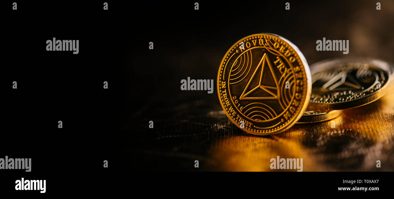 Closeup of golden tron coin TRX cryptocurrency over black and gold ...