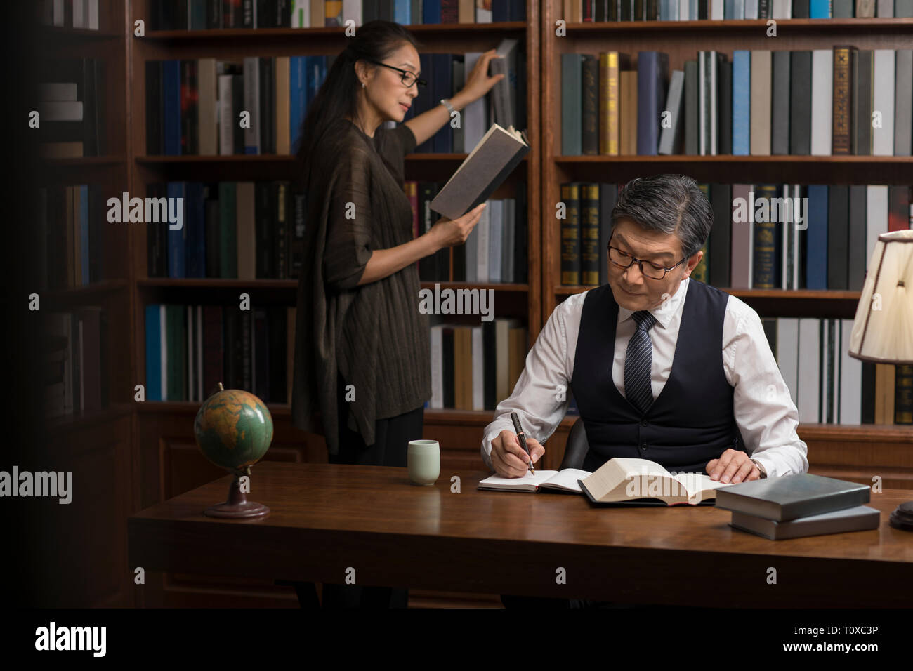 Mature couple reading books in study Stock Photo - Alamy