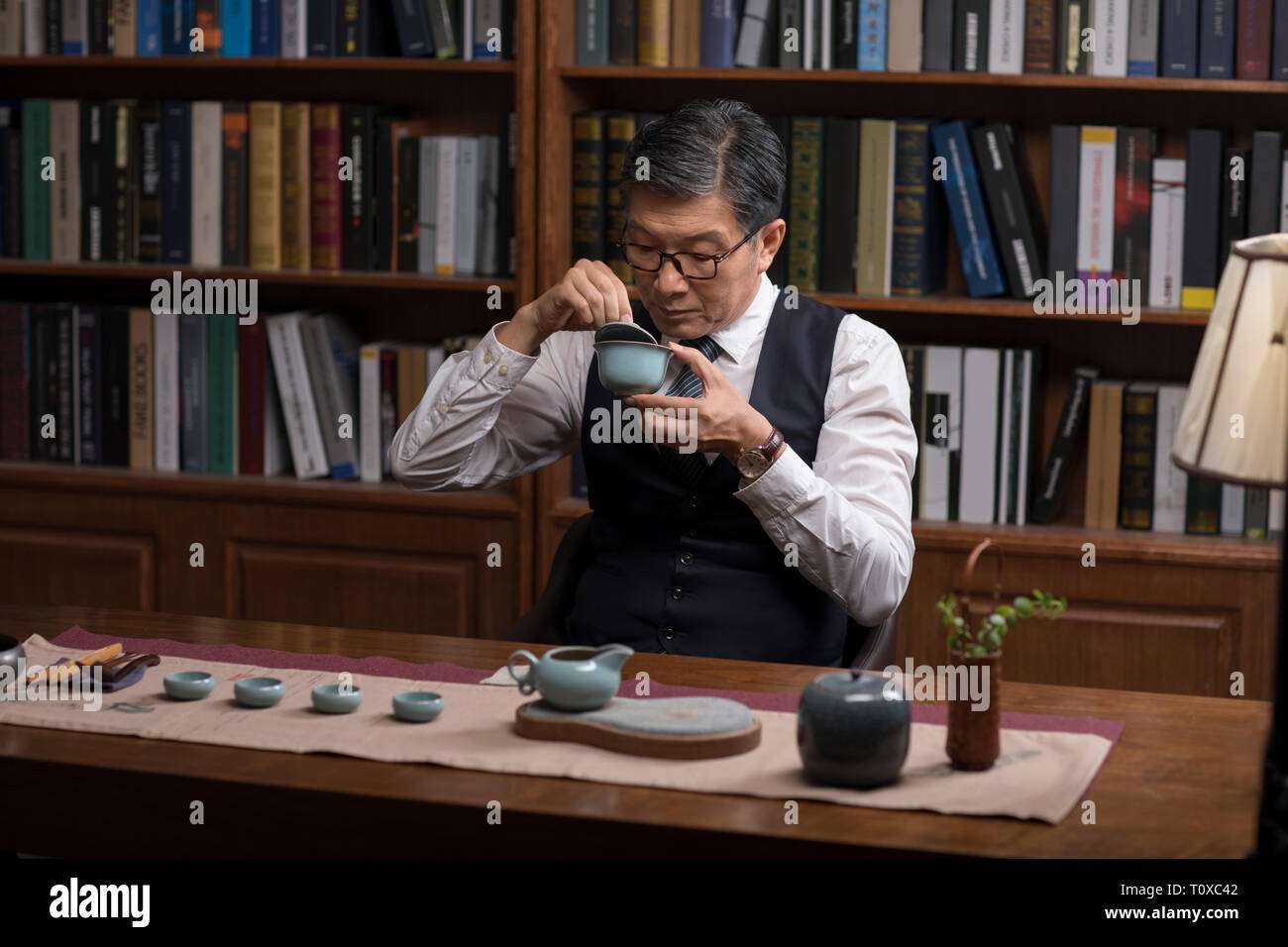 Senior businessman drinking tea in study Stock Photo - Alamy