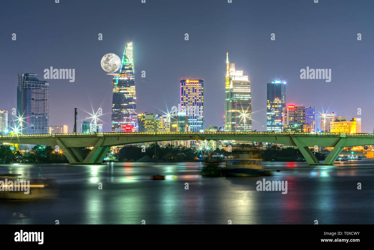 Night scene shimmering in a riverside urban area with skyscrapers ...