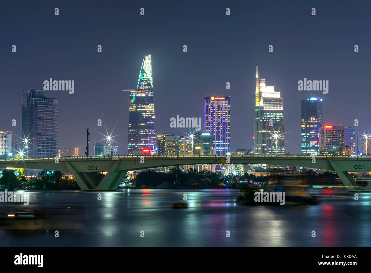 Night scene shimmering in a riverside urban area with skyscrapers ...