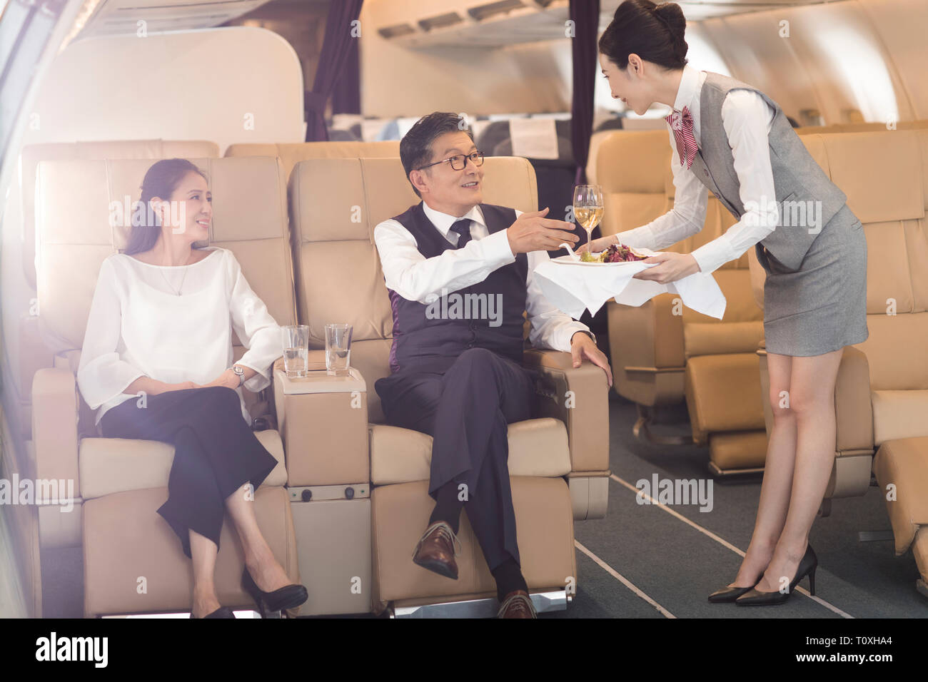 Airline stewardess serving food to passengers Stock Photo - Alamy