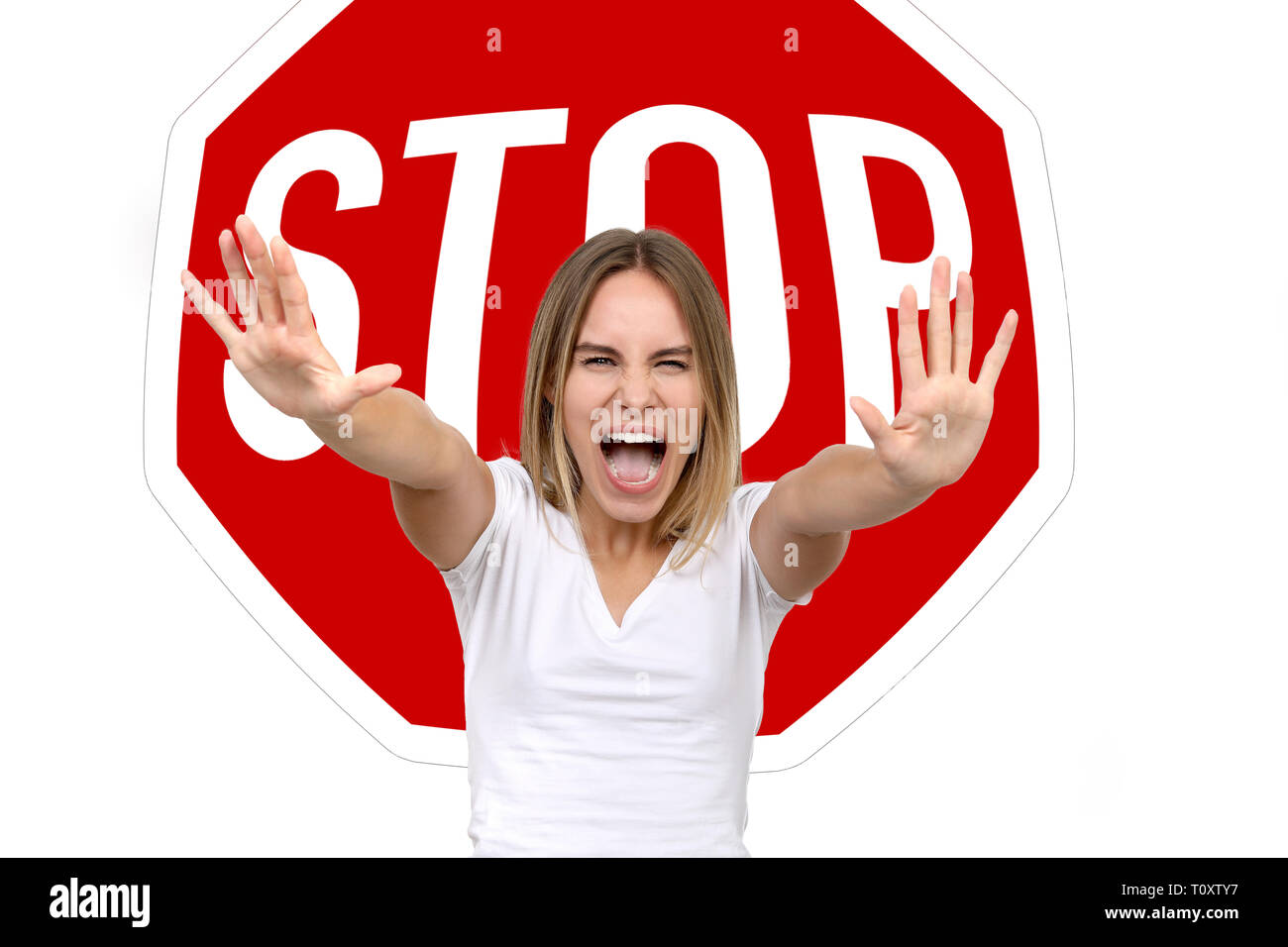 Blond woman shouts and raises her hands in front of a stop sign Stock ...