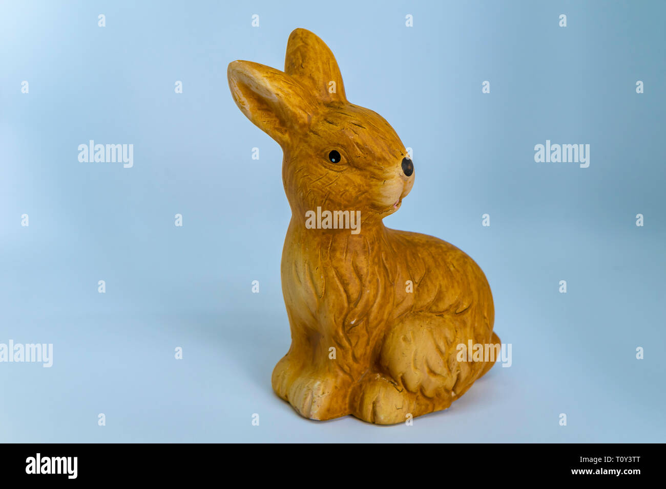 Brown ceramic rabbit in front of a blue background as the basis for an ...