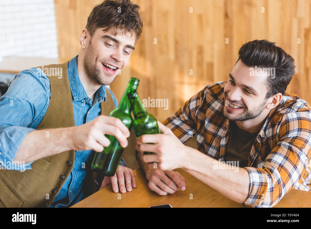 handsome and smiling men cheering with glass bottles of beer Stock ...