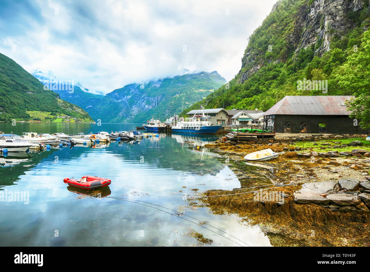 Marina in the norwegian town Geiranger and view of the Geiranger fjord ...