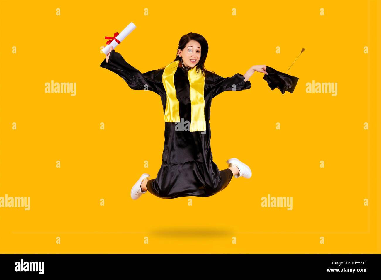 graduate student with a diploma in jumping on an orange background ...