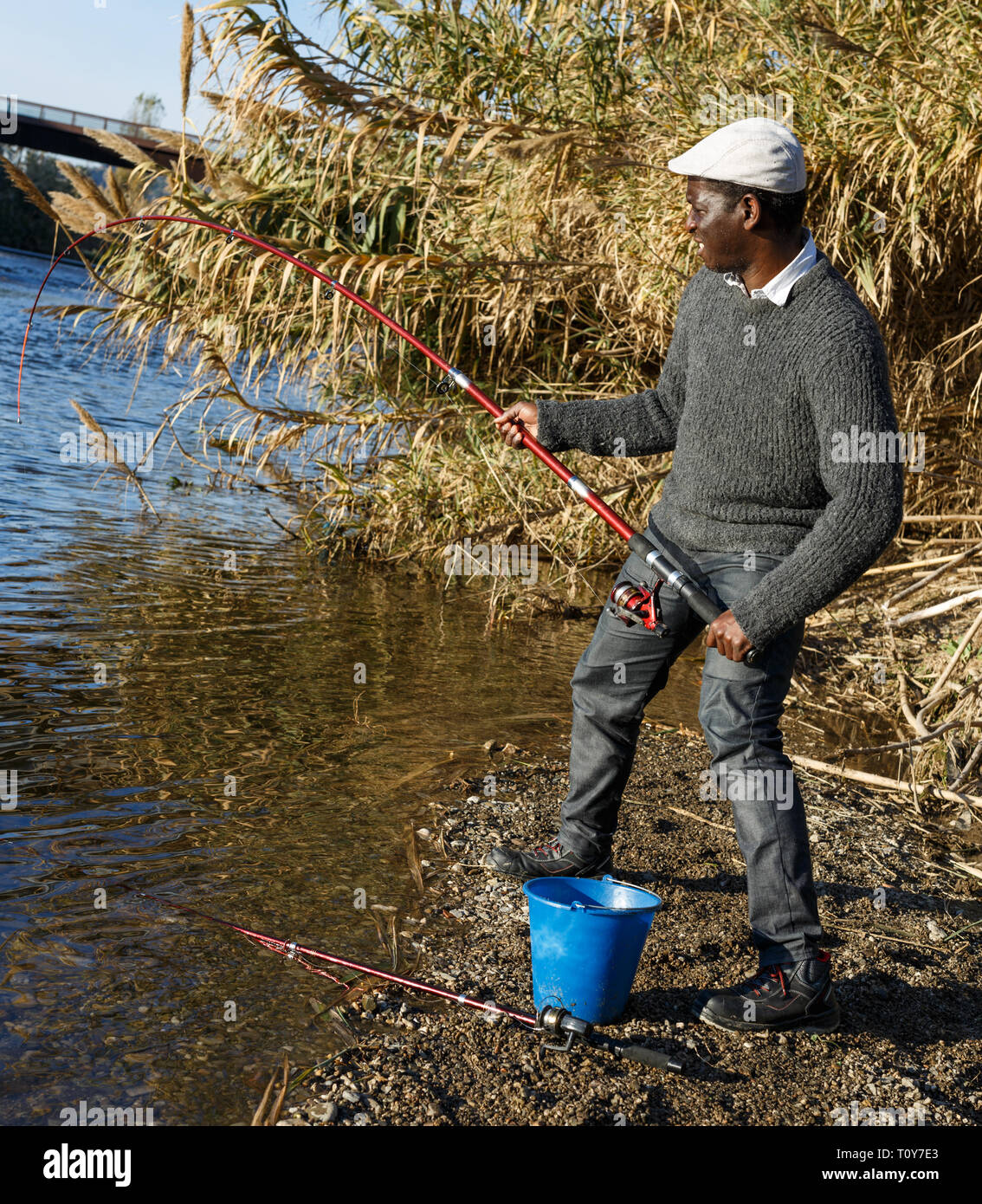 Emotional portrait of African man pulling with rod fish on river Stock ...