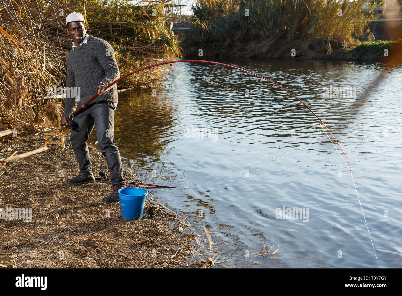 Emotional portrait of African man pulling with rod fish on river Stock ...