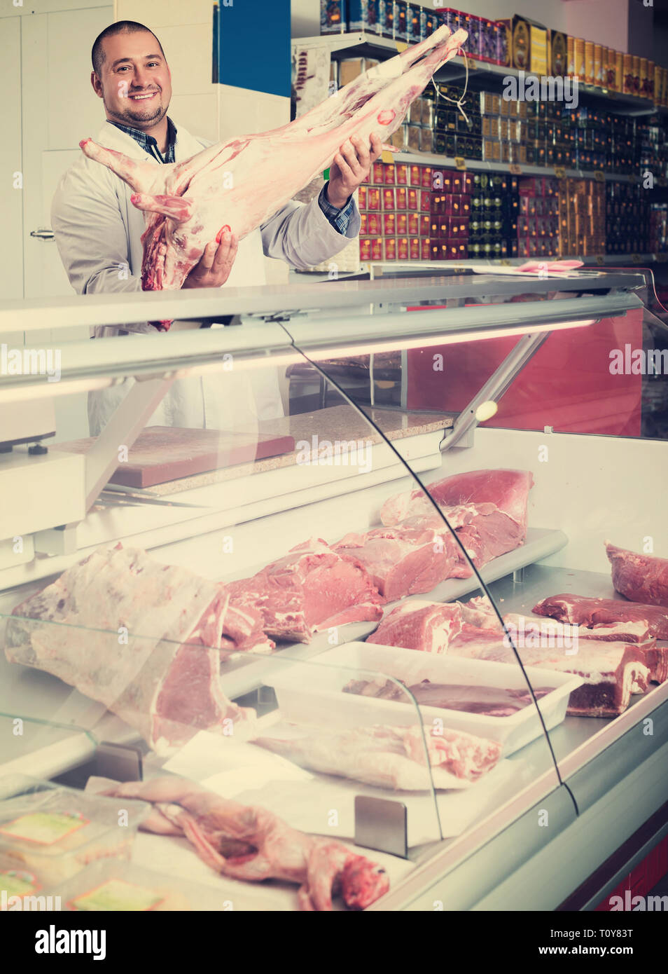 Professional butcher cutting fresh lamb meat in workshop Stock Photo ...