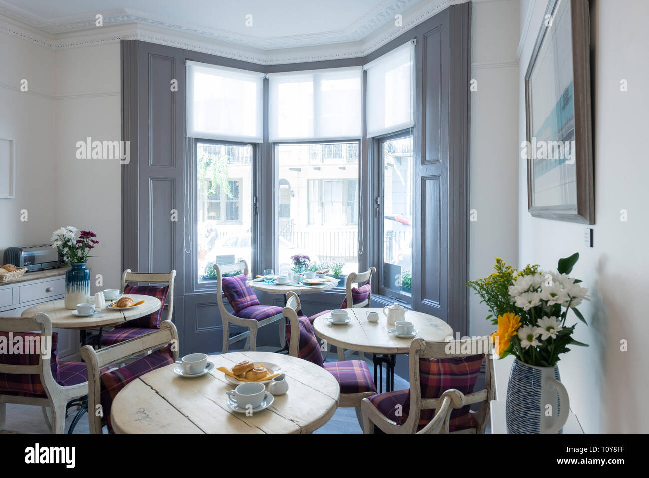 a dining room in a bed and breakfast hotel is laid out for breakfast ...
