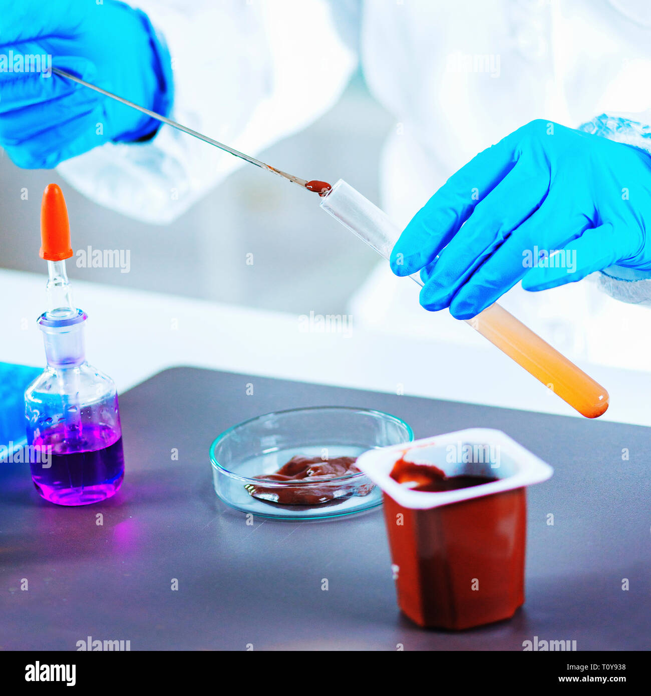 Quality control expert inspecting chocolate pudding in the laboratory ...