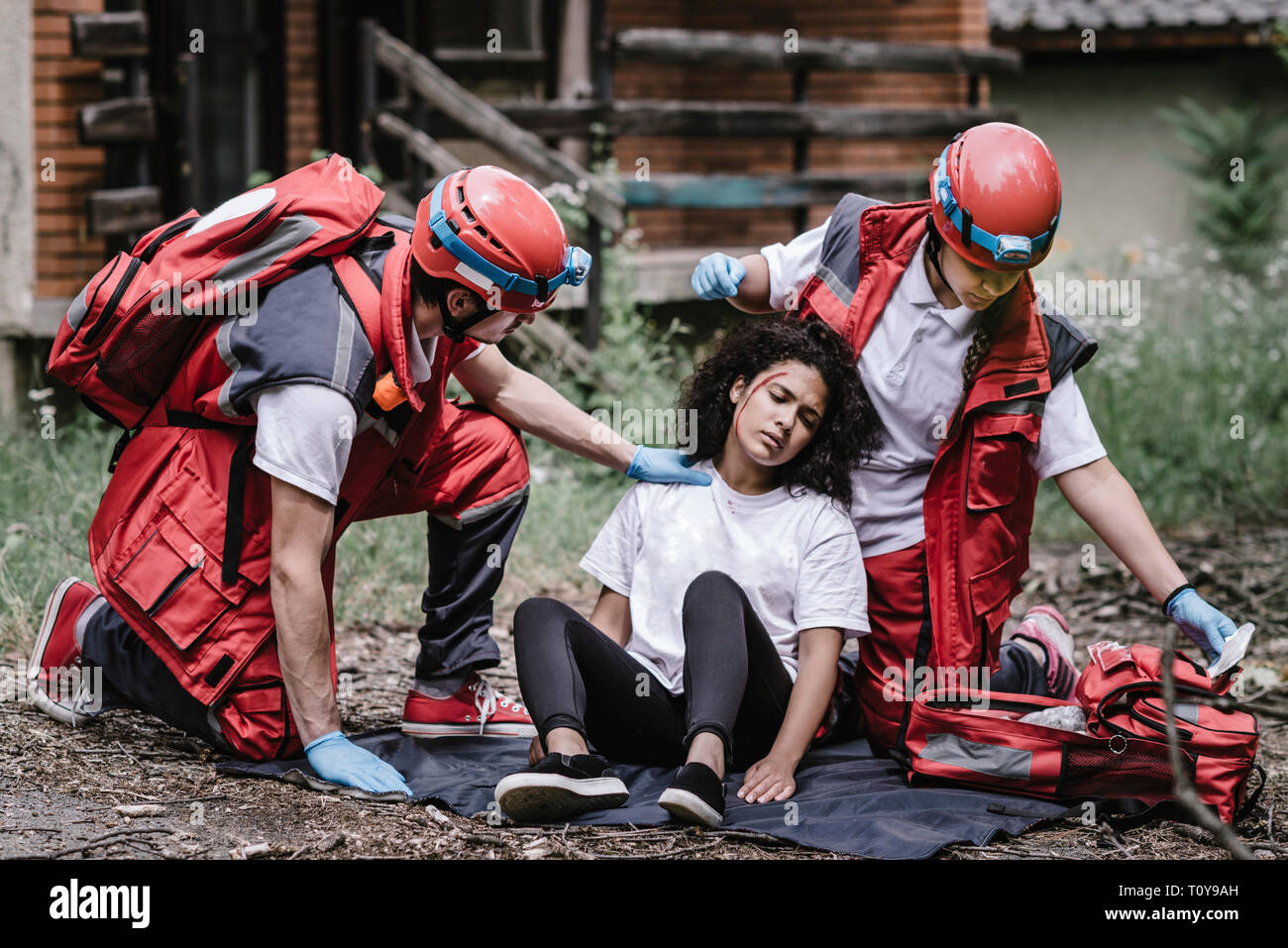 Rescue team helping injured woman Stock Photo - Alamy