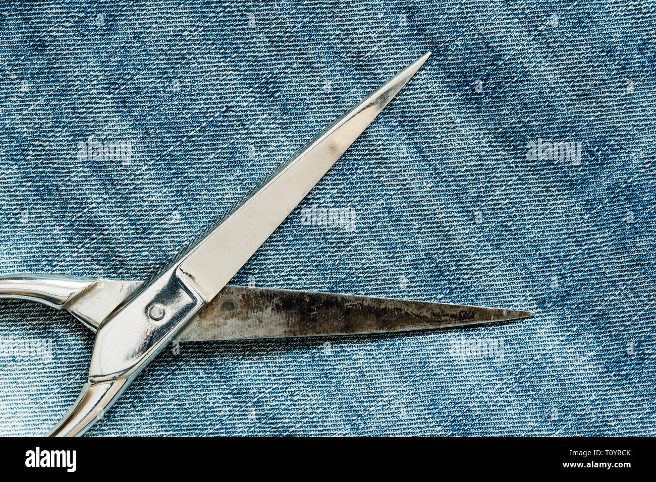 Metal scissors laying on the blue jeans background Stock Photo - Alamy