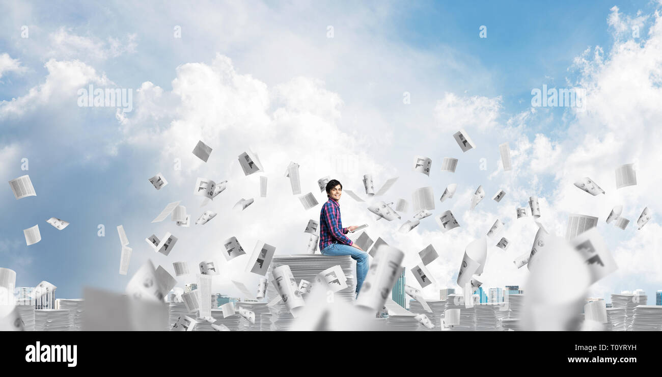 Attractive man sitting on pile of paper documents Stock Photo - Alamy