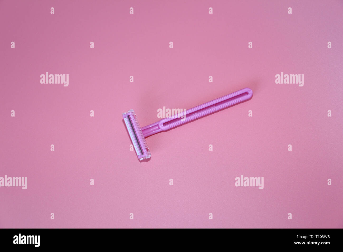 One razor is lying on a pink background. Pink razor on a pink ...