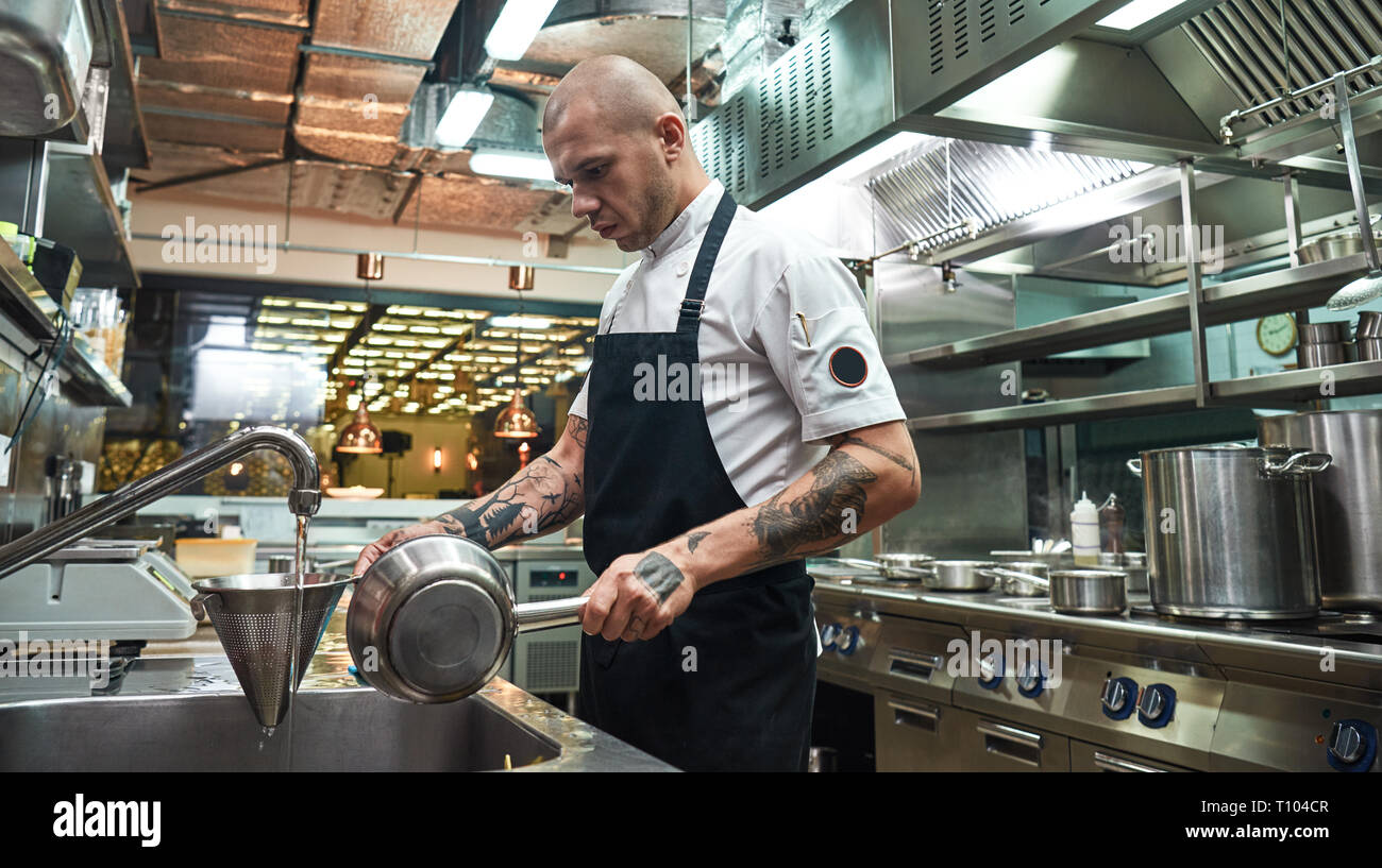 Cooling down. Serious professional chef holding cooked pasta in a ...