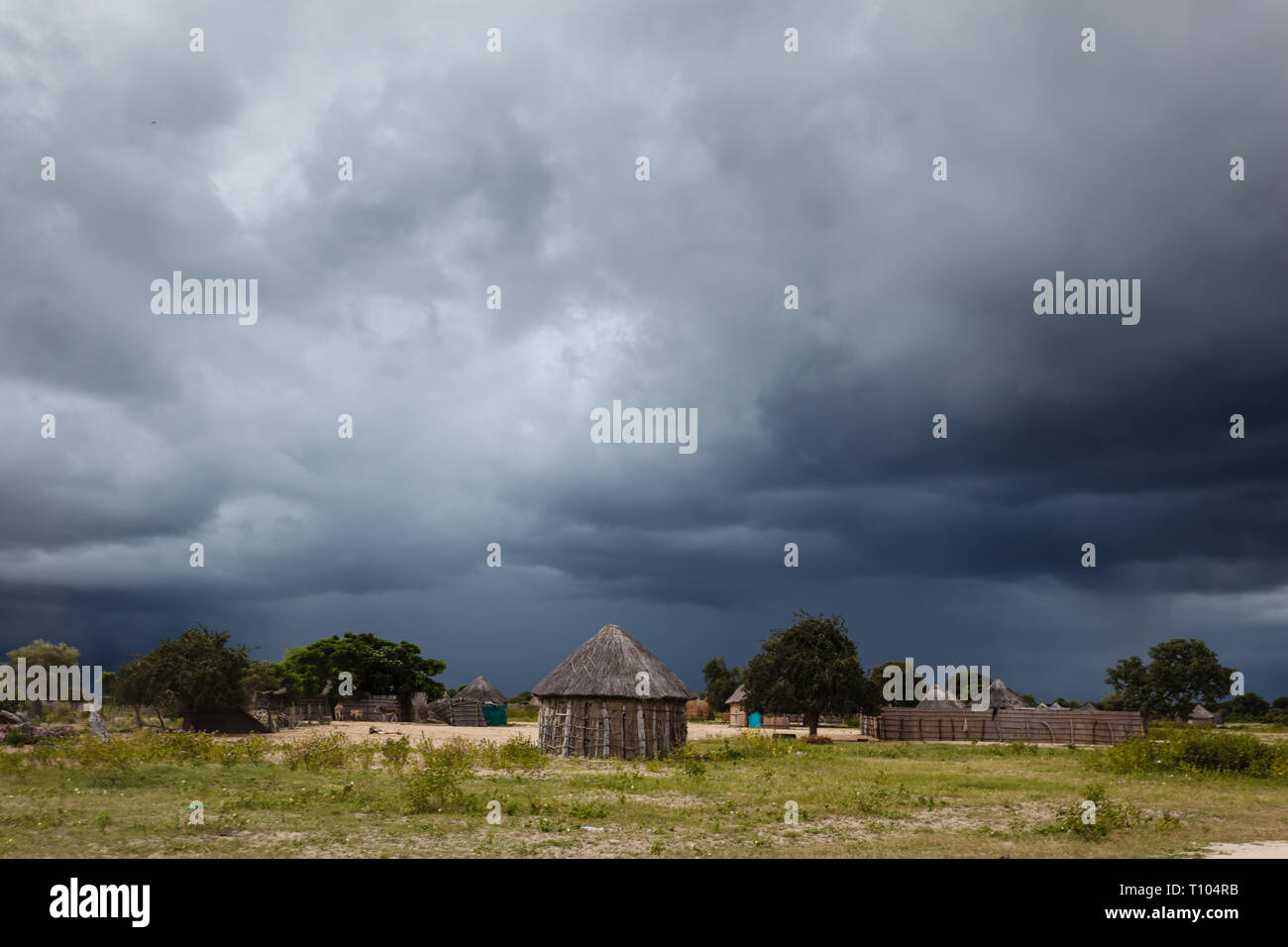 Storm clouds overtake Okavanga village with its round straw houses and ...