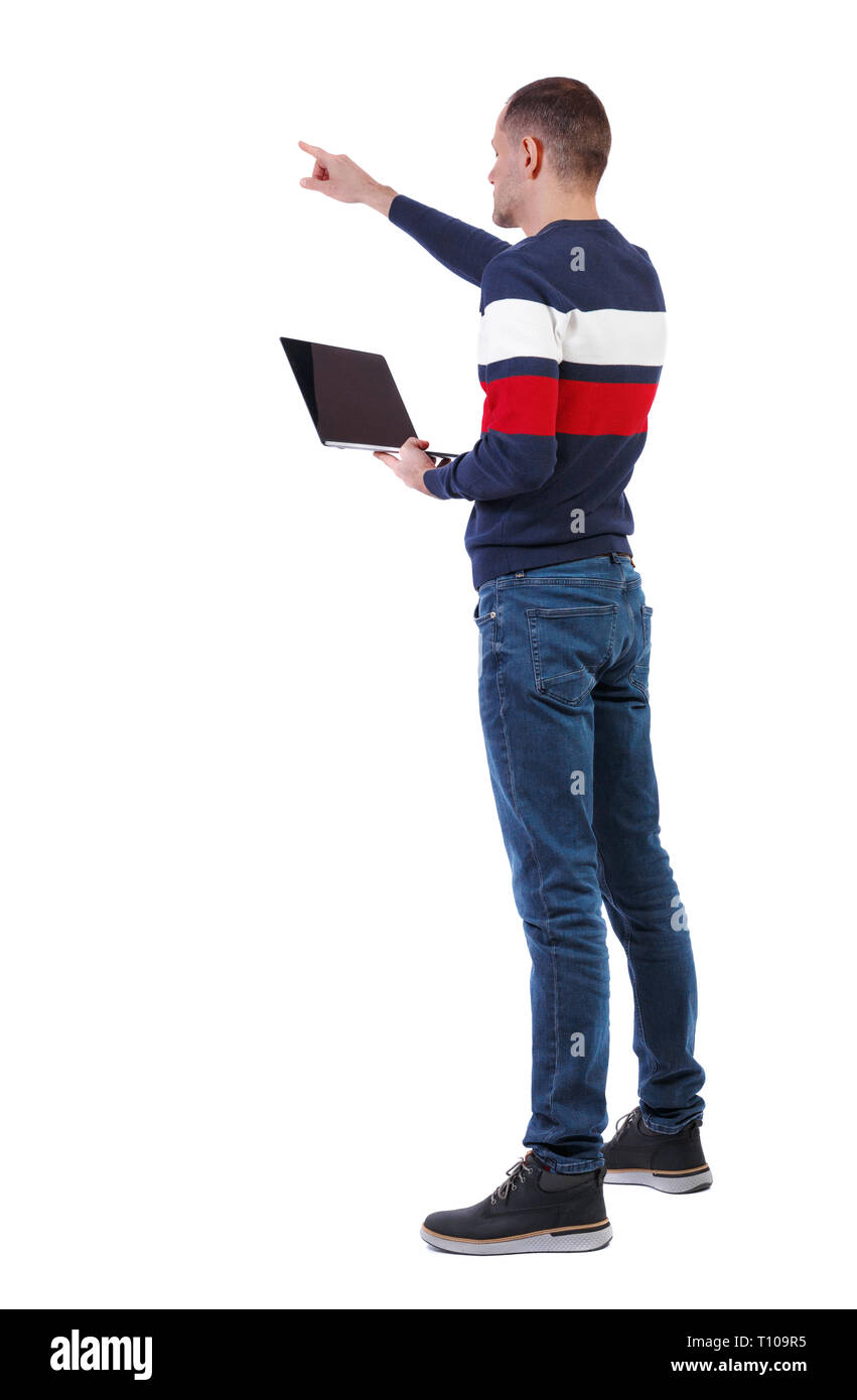 Back view of a pointing man who is standing with a laptop. Rear view ...