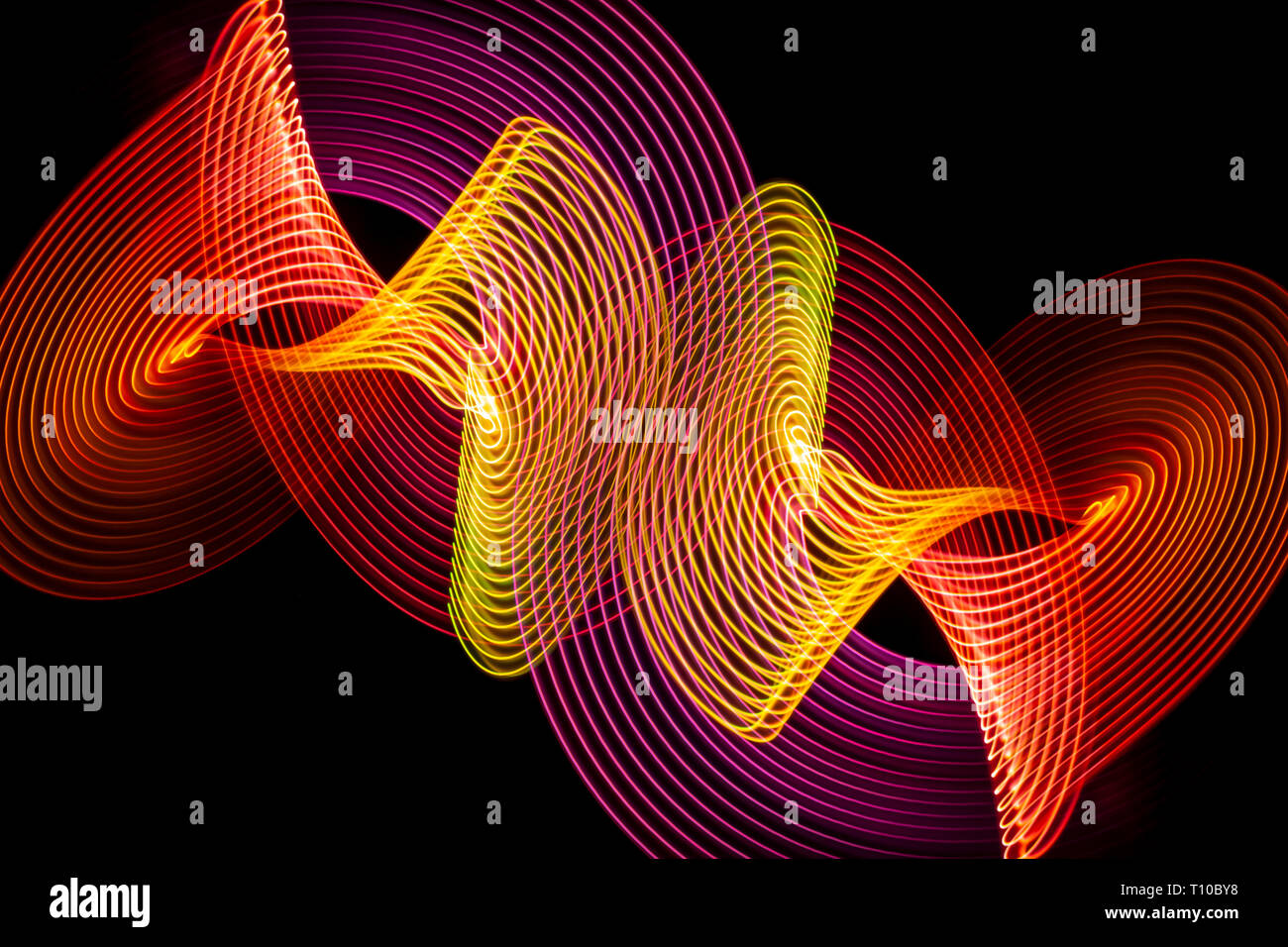 Colorful pink, yellow, red neon spiral lines.Abstract background of ...