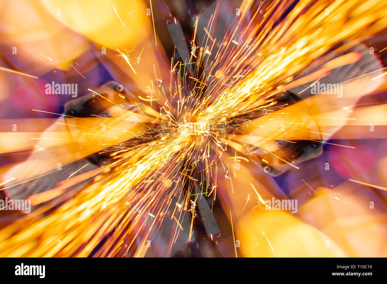 Bright orange and yellow sparks on a black background. A stream of ...