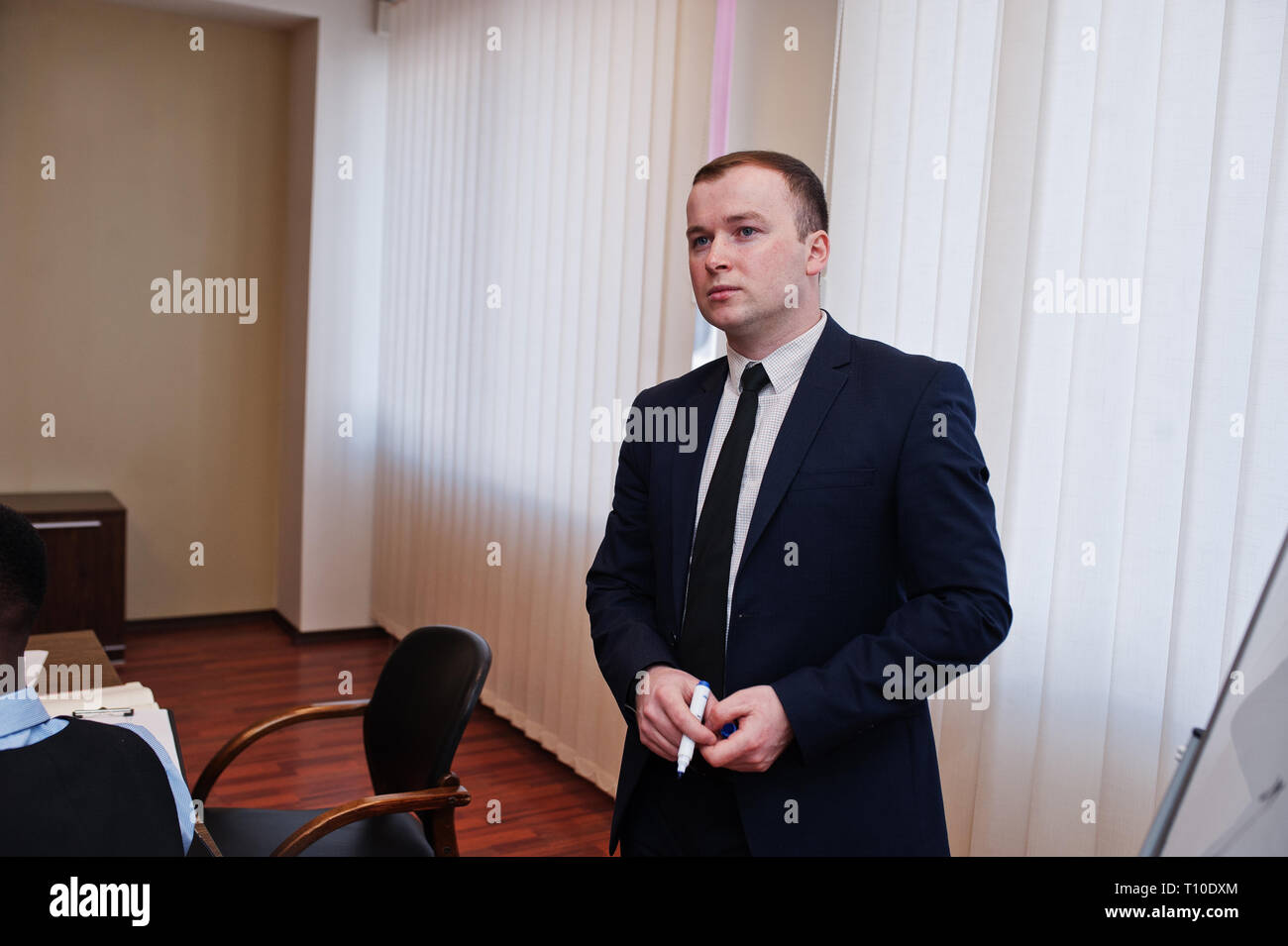 Young creative man at suit in modern office. Successful businessman in ...