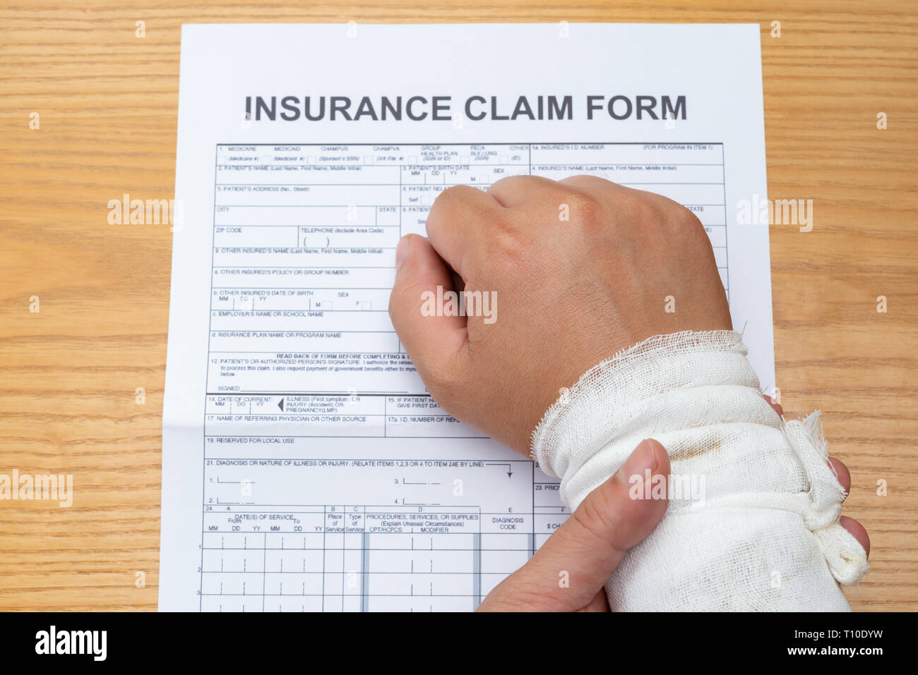 man with wrapped hand reading a work injury claim form Stock Photo - Alamy