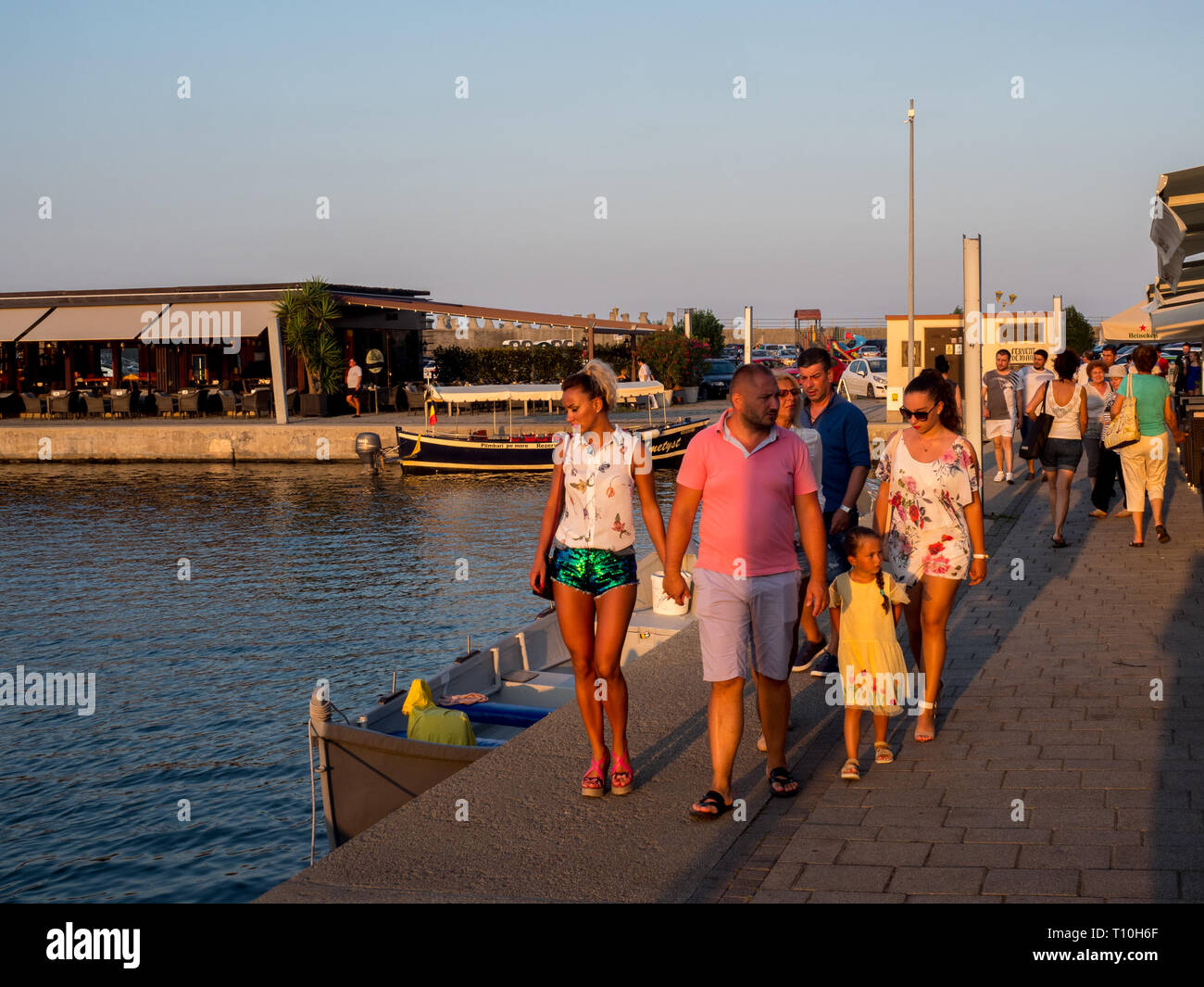 A family take an evening stroll around Constanta marina Stock Photo - Alamy