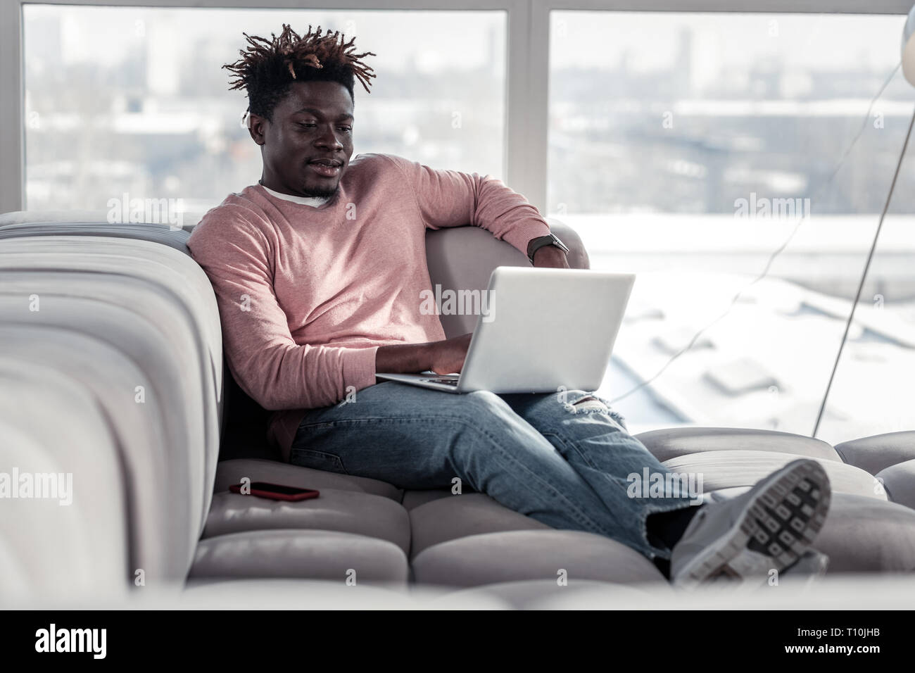 Positive delighted male person keeping laptop on knees Stock Photo - Alamy