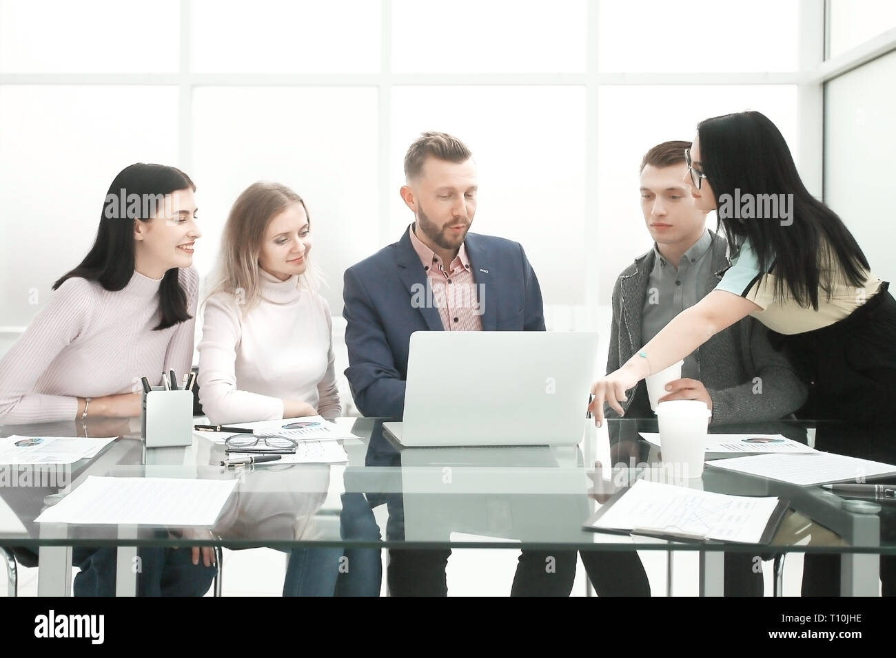 Manager pointing to laptop screen during working meeting Stock Photo ...