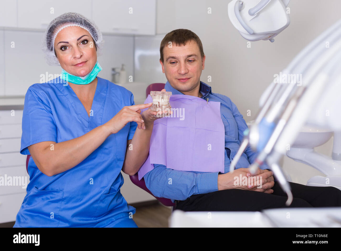 professional positive doctor woman and patient sitting in medical chair ...