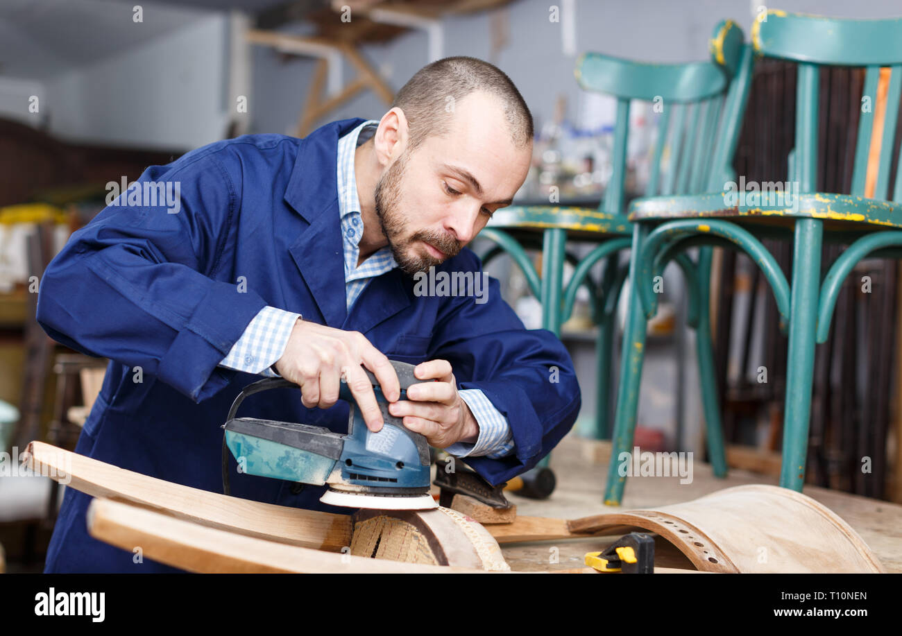 Furniture restorer renovation antique chair in his woodwork studio ...