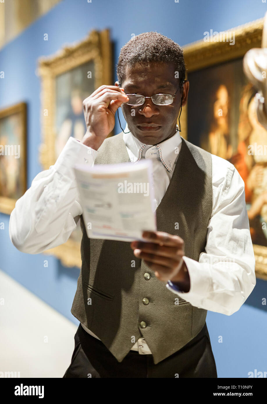 Mature african man reading brochure about exhibits on exposition of ...